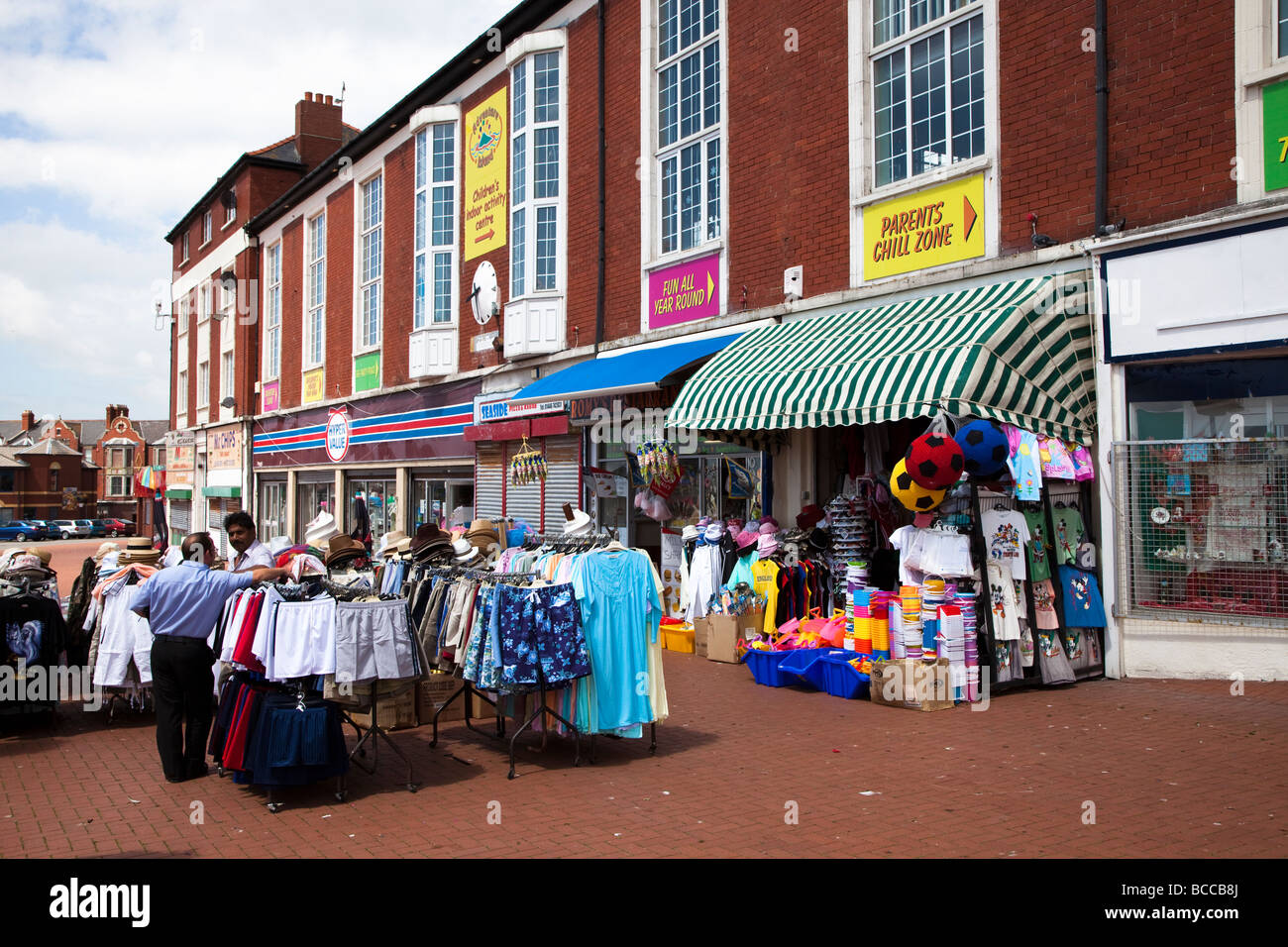 Street trader selling clothes outside shop on sea front Barry island ...