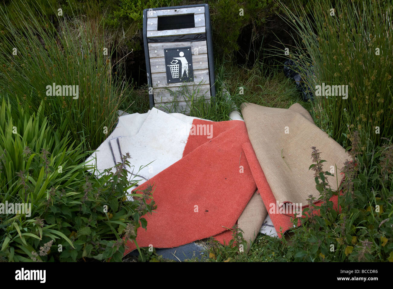 old carpets discarded next to a litter bin in a rural beauty spot in ...