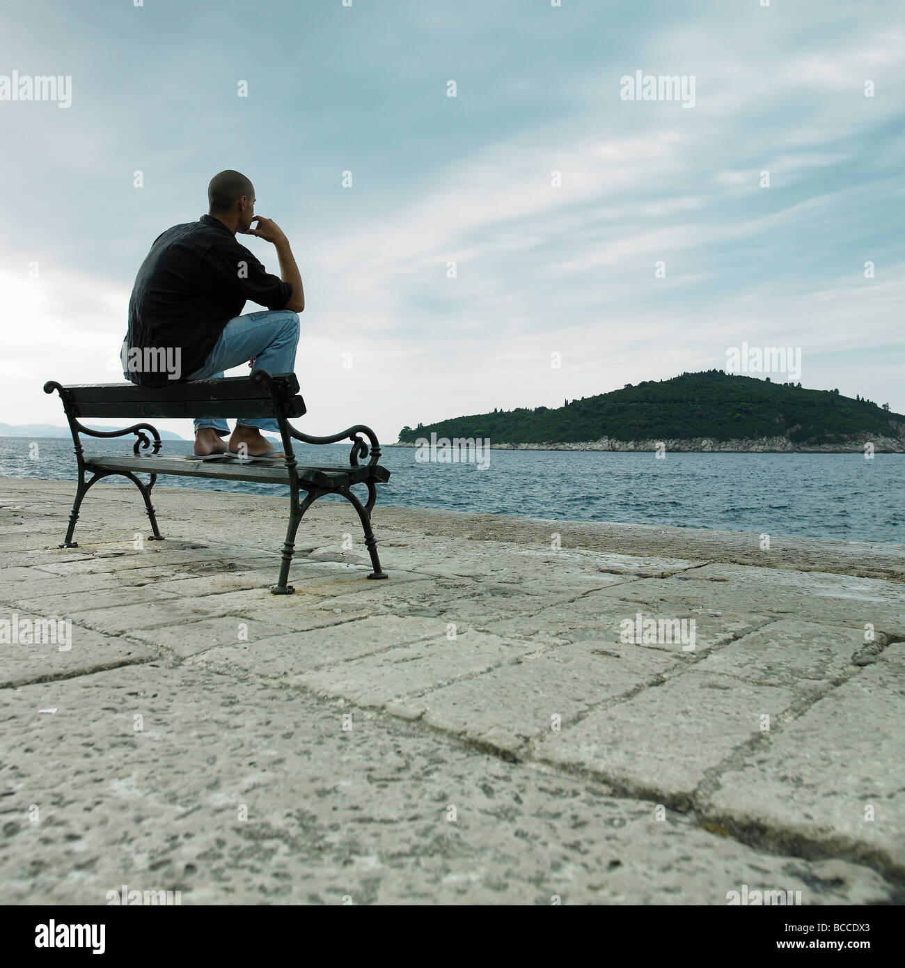 young man sitting on bench, rear view Stock Photo - Alamy