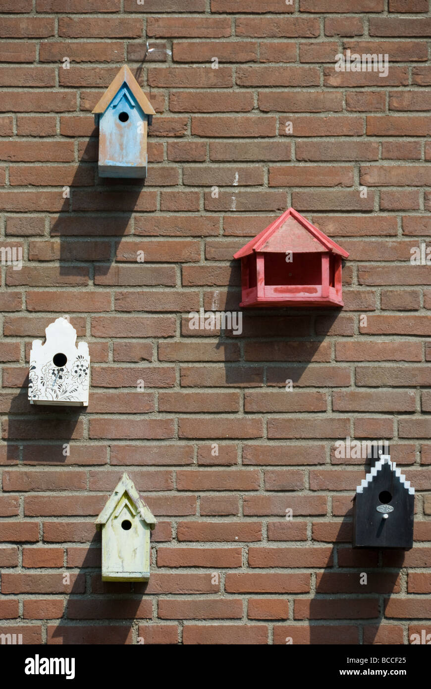 Bird houses on a brick wall Stock Photo - Alamy