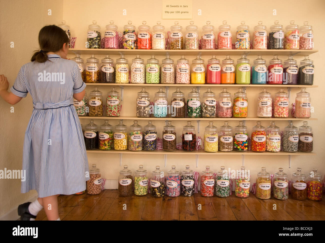 Schoolgirl perusing jars of sweets in traditional sweet shop, Market ...