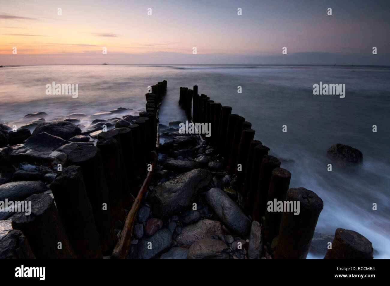 Atmospheric sunset over timber groynes on the North Devon coast at ...