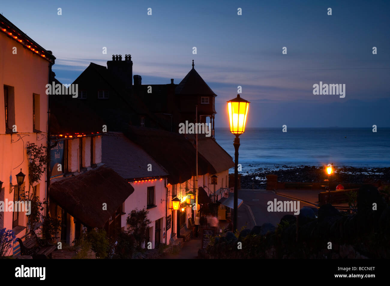 Pubs and hotels lit by street lanterns on the steep narrow path beside ...