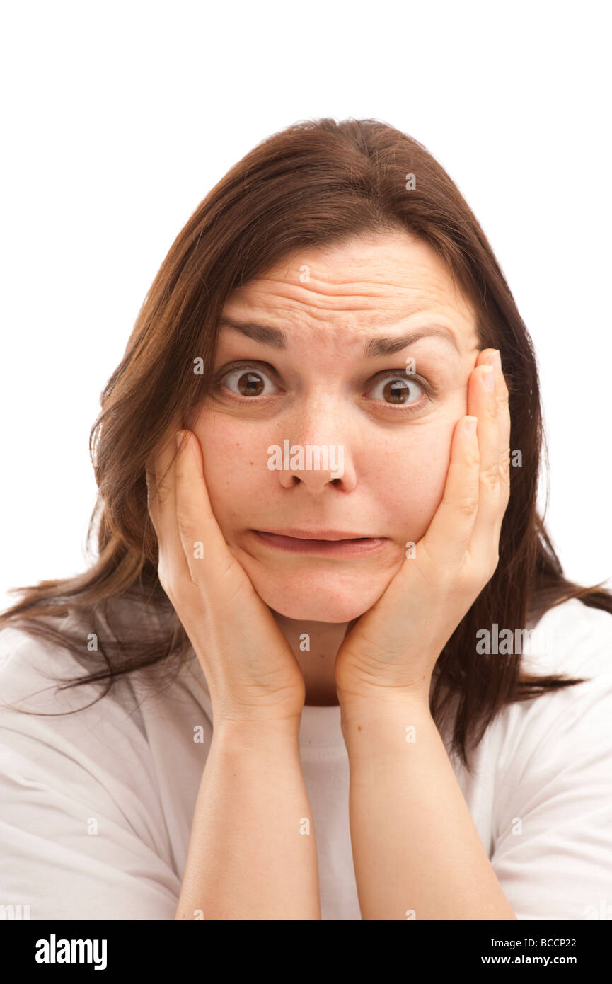 A woman holding her head in her hands looking horrified scared worried ...