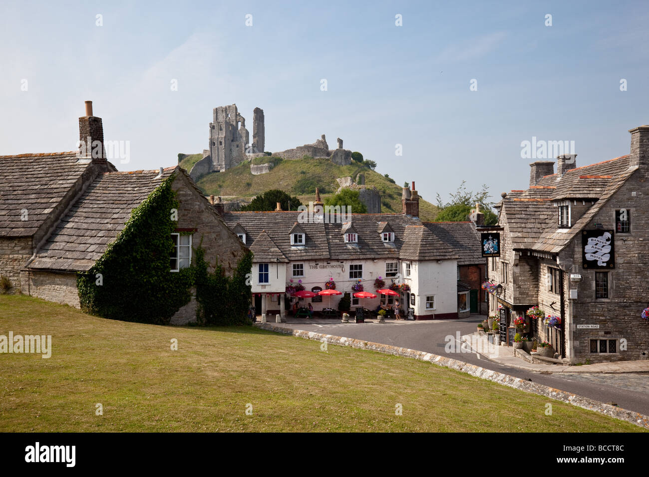 The village of Corfe Castle, nestling beneath the ruins of Corfe Castle ...
