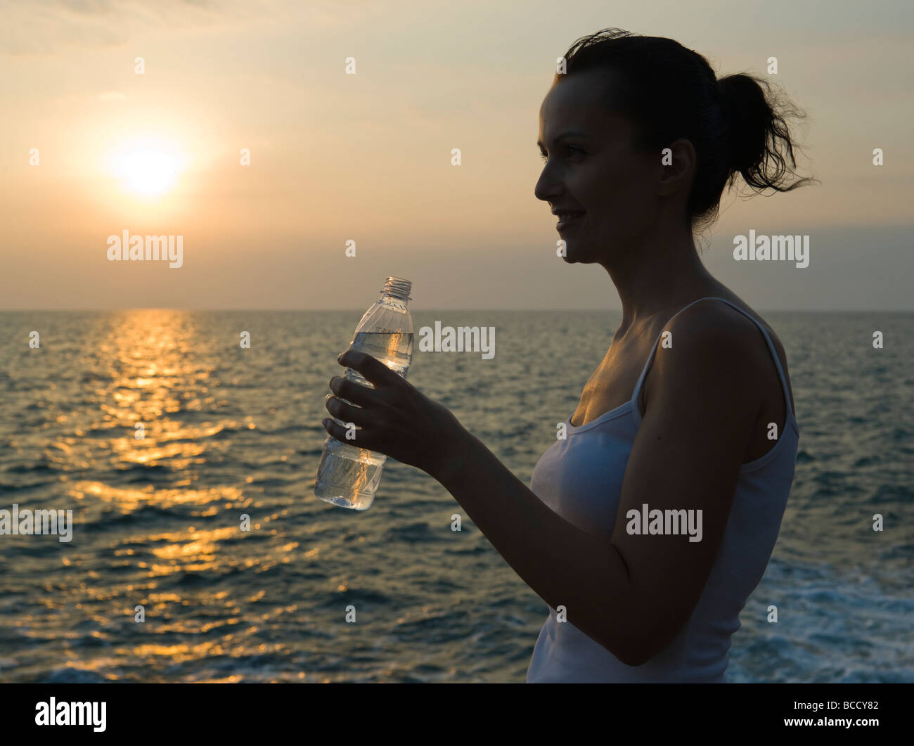 woman caucasian driking water by the seaside with sunset sunrise Stock ...
