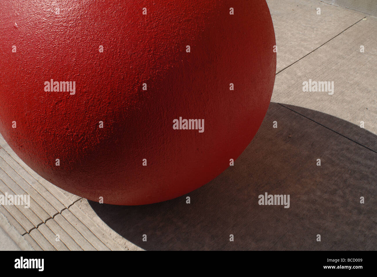 red cement ball on the floor of a target store, shadow, sub, red, lines ...