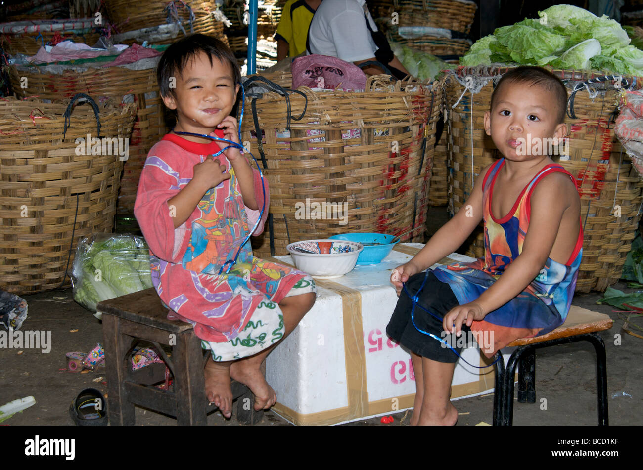 Two happy market children enjoying lunch in Bangkok's fresh food market ...