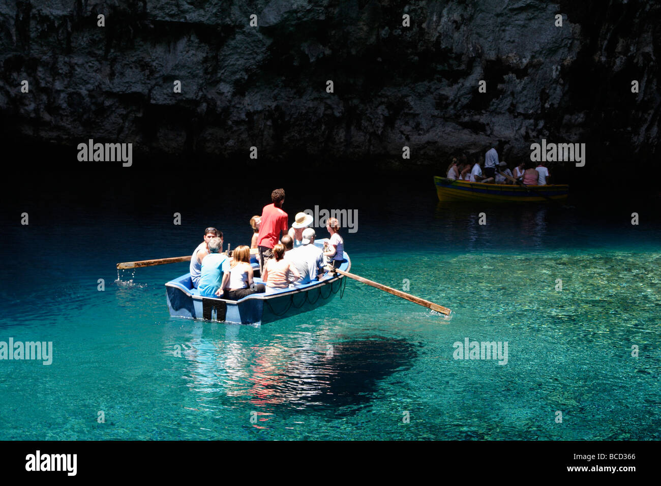 [Rowing boat] floating on clear blue water of [Melissani Lake ...