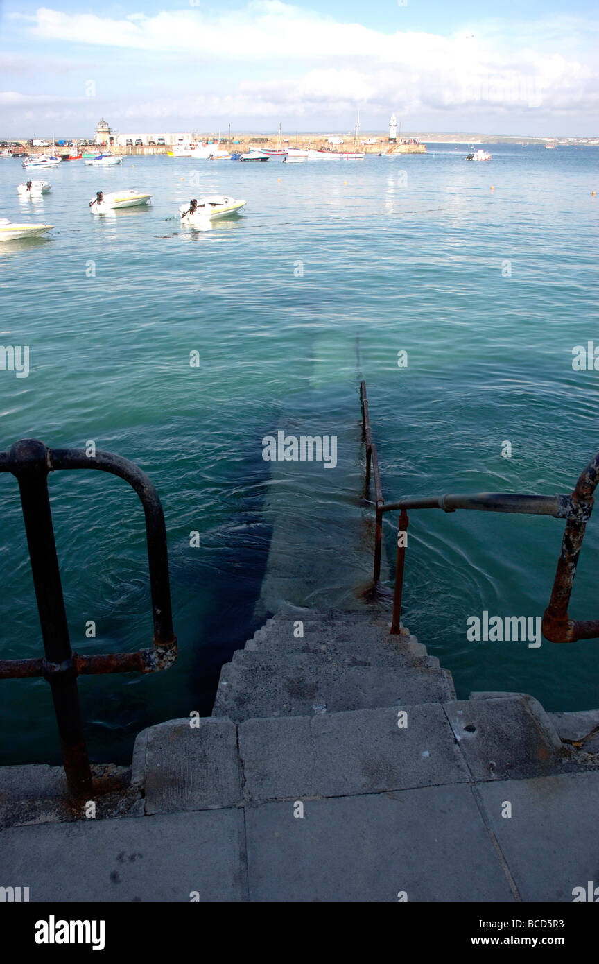 Stone steps leading down to the beach at high tide in the centre of St ...