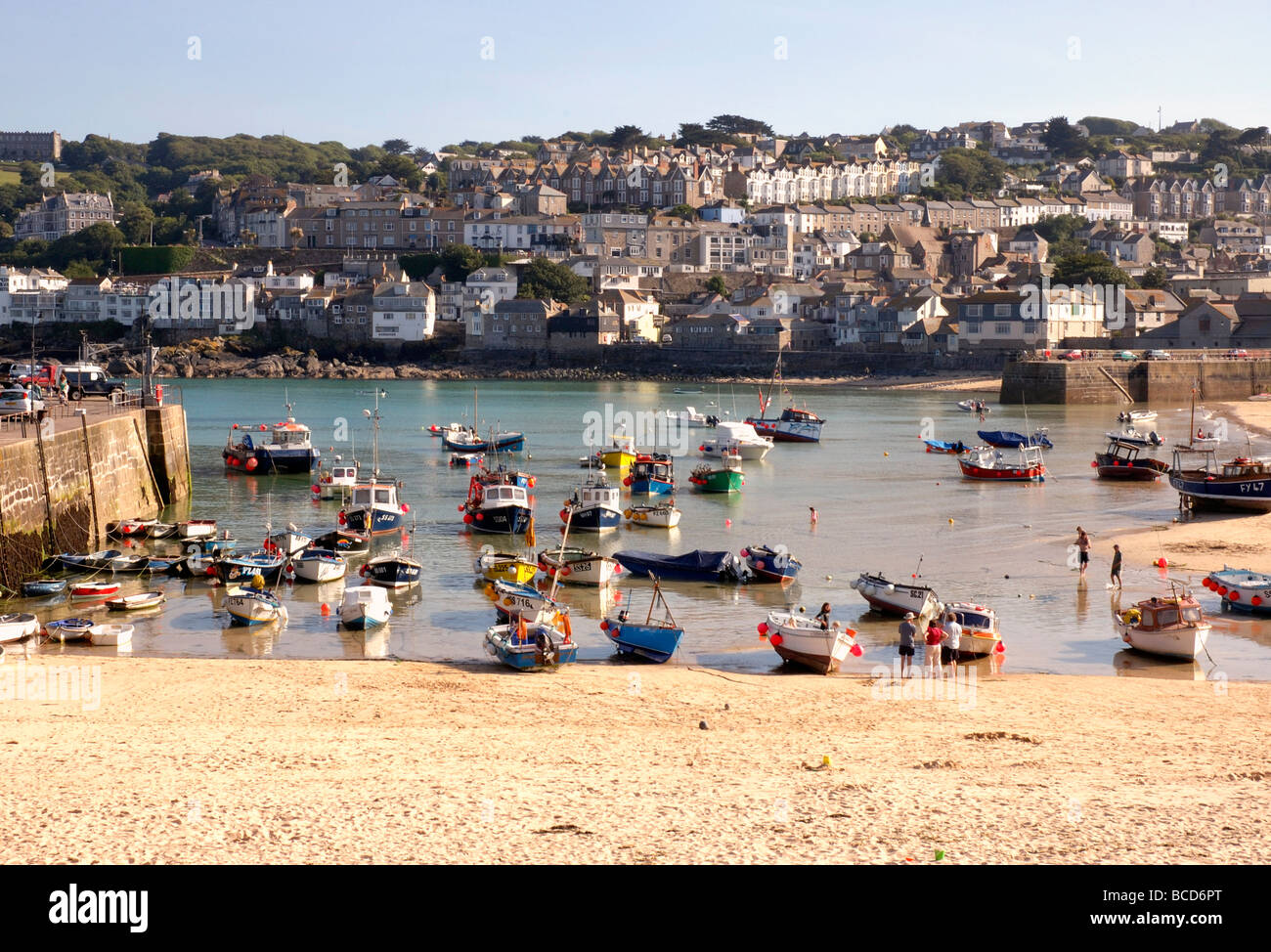 The busy harbour of St Ives in Cornwall at low tide with the old town ...