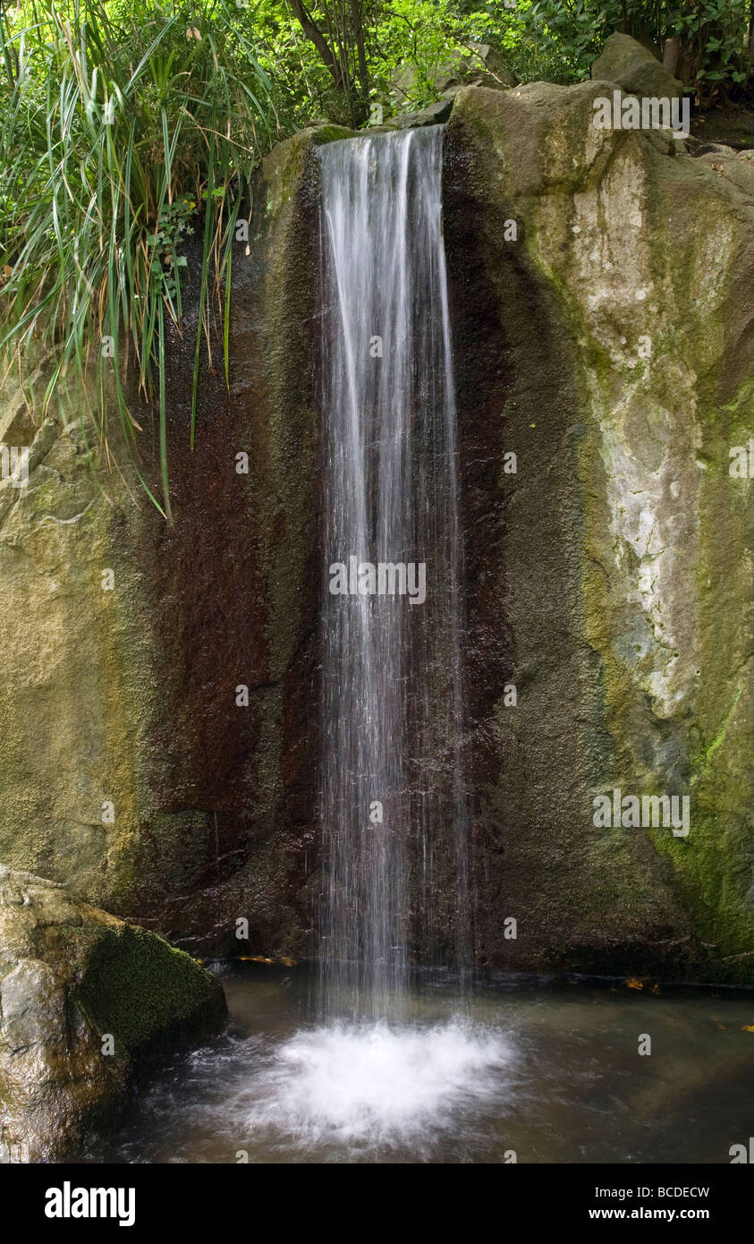 Small spring mountain waterfall and rock behind Stock Photo - Alamy