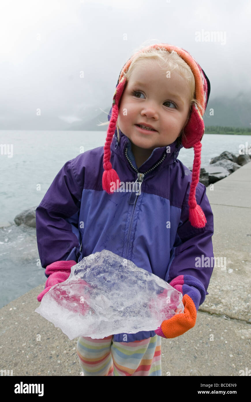 A baby girl holding a piece of ice from Portage Glacier Stock Photo - Alamy