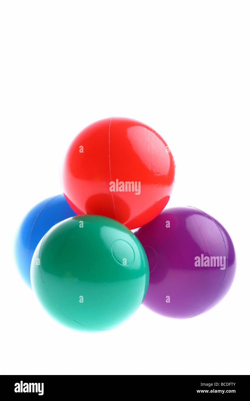 Pyramid made of four shiny coloured plastic toy balls isolated on white ...