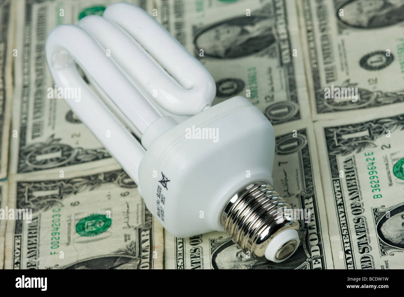 lighting bulb with a money on background Stock Photo - Alamy