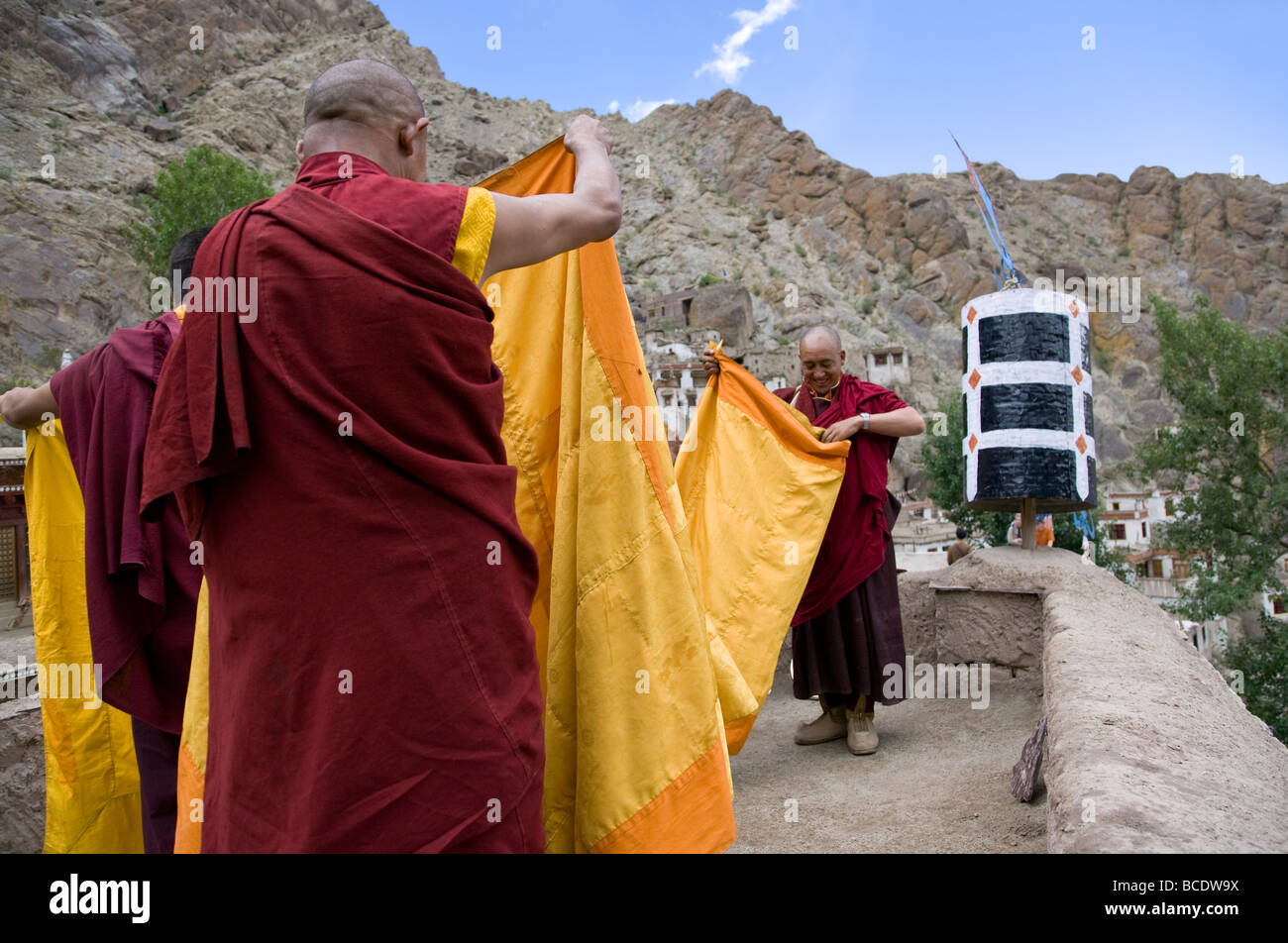 Buddhist monks folding the yellow robes on the roof of Hemis Gompa ...