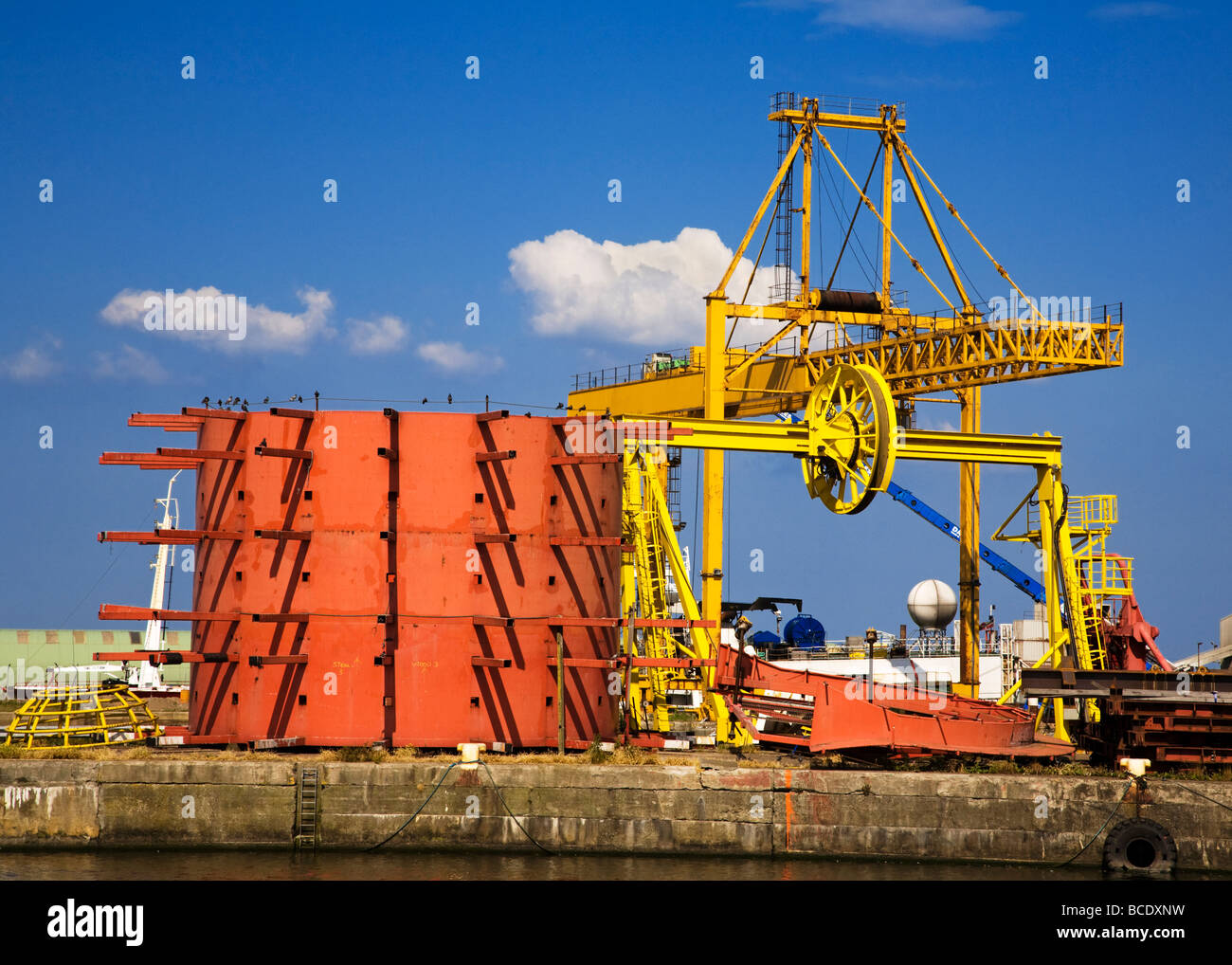 A steel cylinder under construction and crane on the quayside at Leith ...