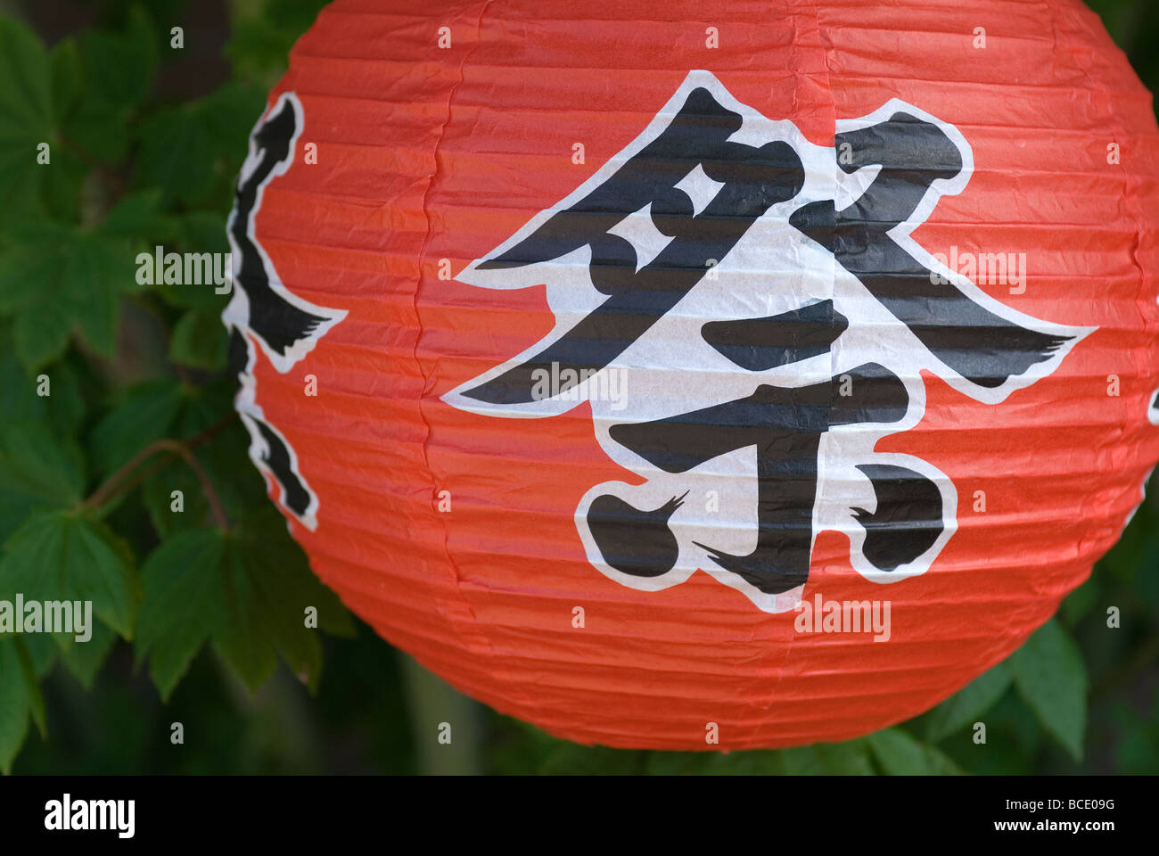 A bright red paper chochin lantern with the Japanese kanji character ...