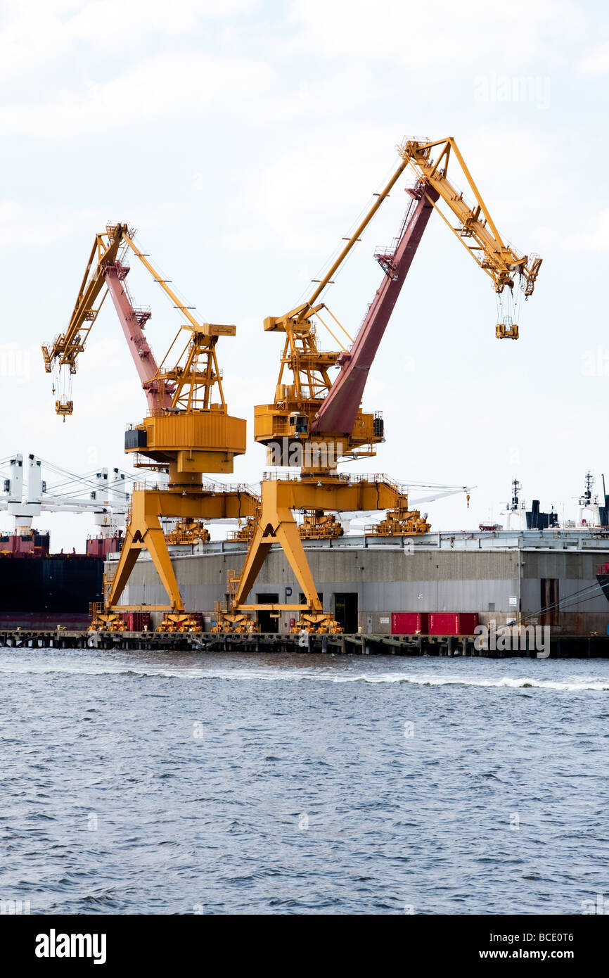 Heavy duty yellow cranes on rails for loading cargo onto ships at a ...