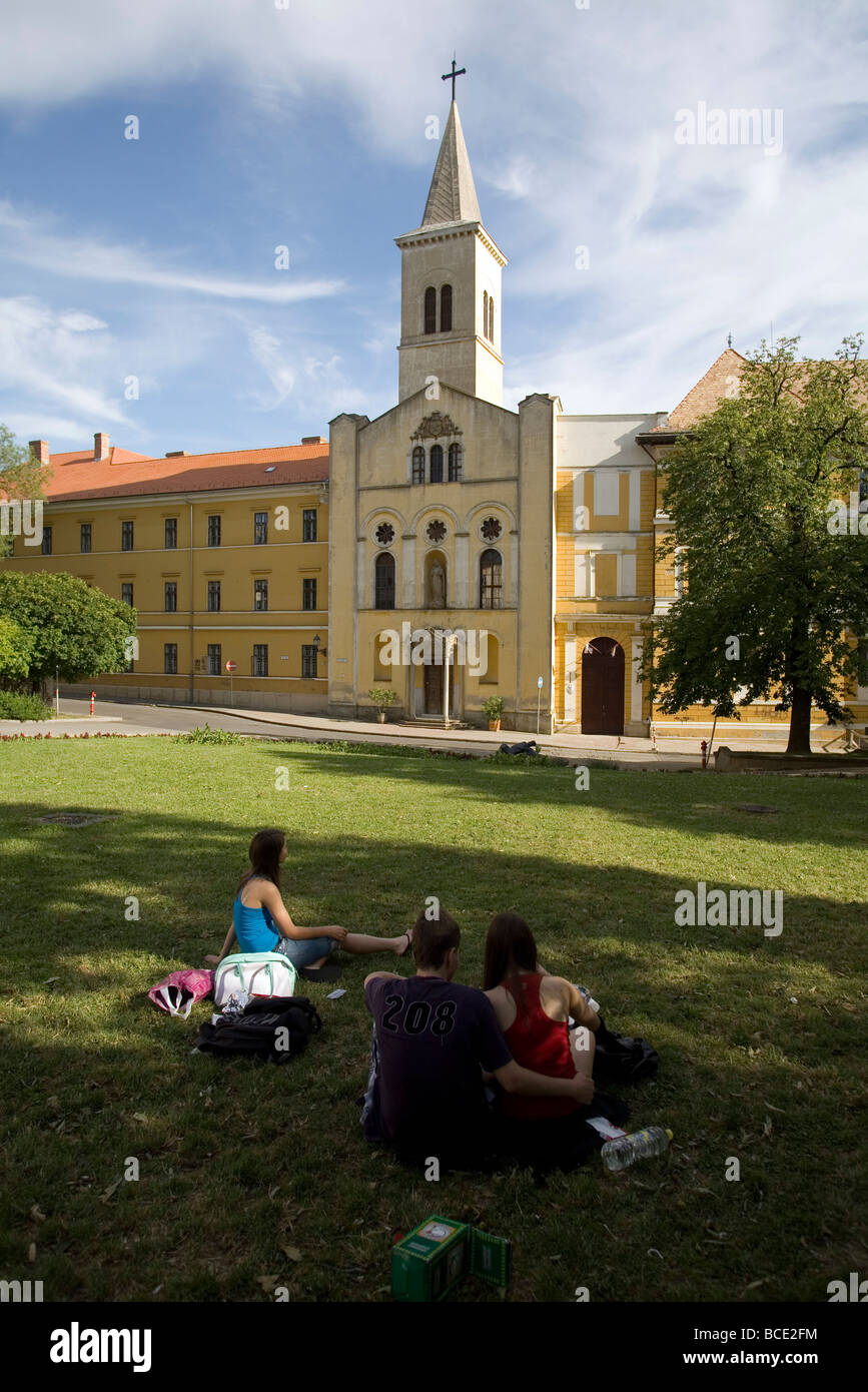 Teenagers picnic in a park opposite the church in Szent Istvan Ter in ...