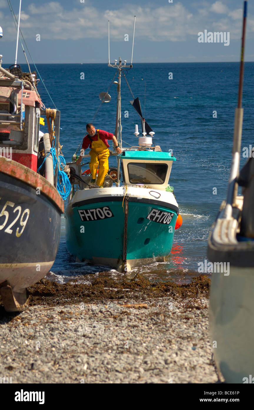 Fisherman landing his trawler on the beach at Cadgwith Cove after a ...