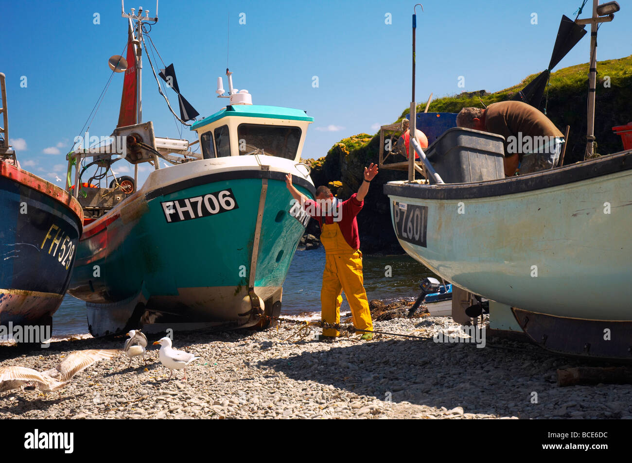 Fishermen landing and docking a fishing trawler on the beach at ...