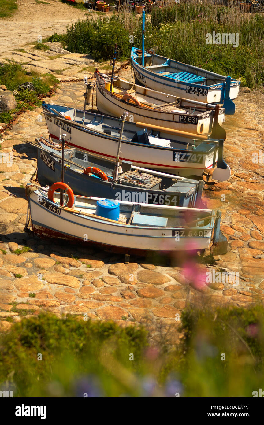 A row of small fishing boats on the cobbled slipway at Penberth Cove in ...