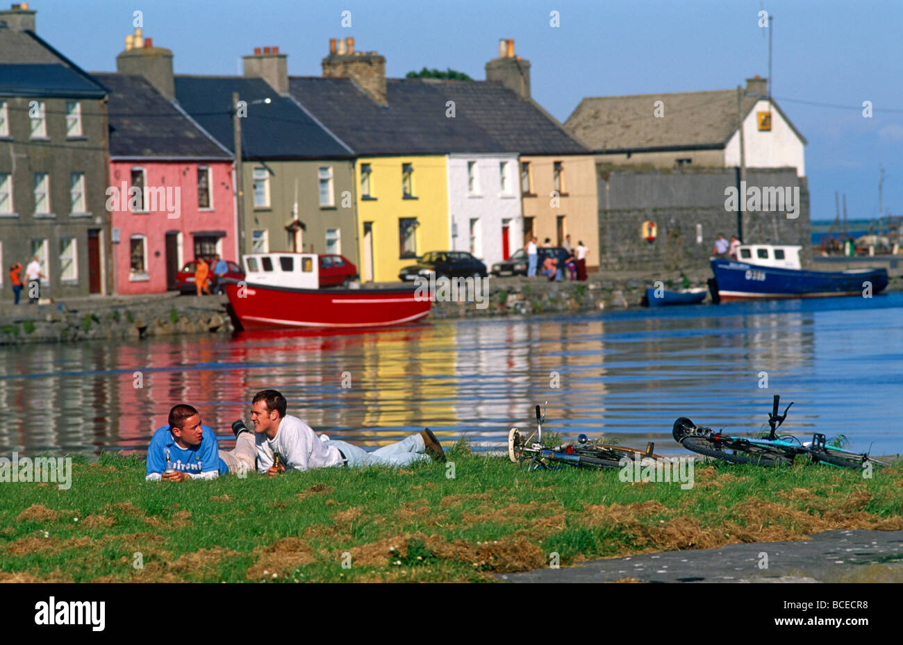 Ireland, Co. Galway. Two men relaxing, Galway Bay, Galway town, Co ...