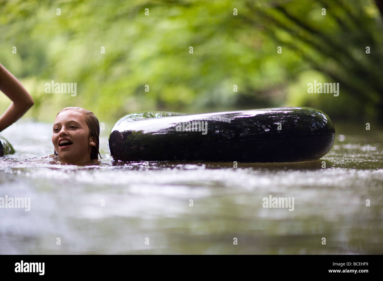 Teenagers having fun in innertubes in the water Stock Photo - Alamy