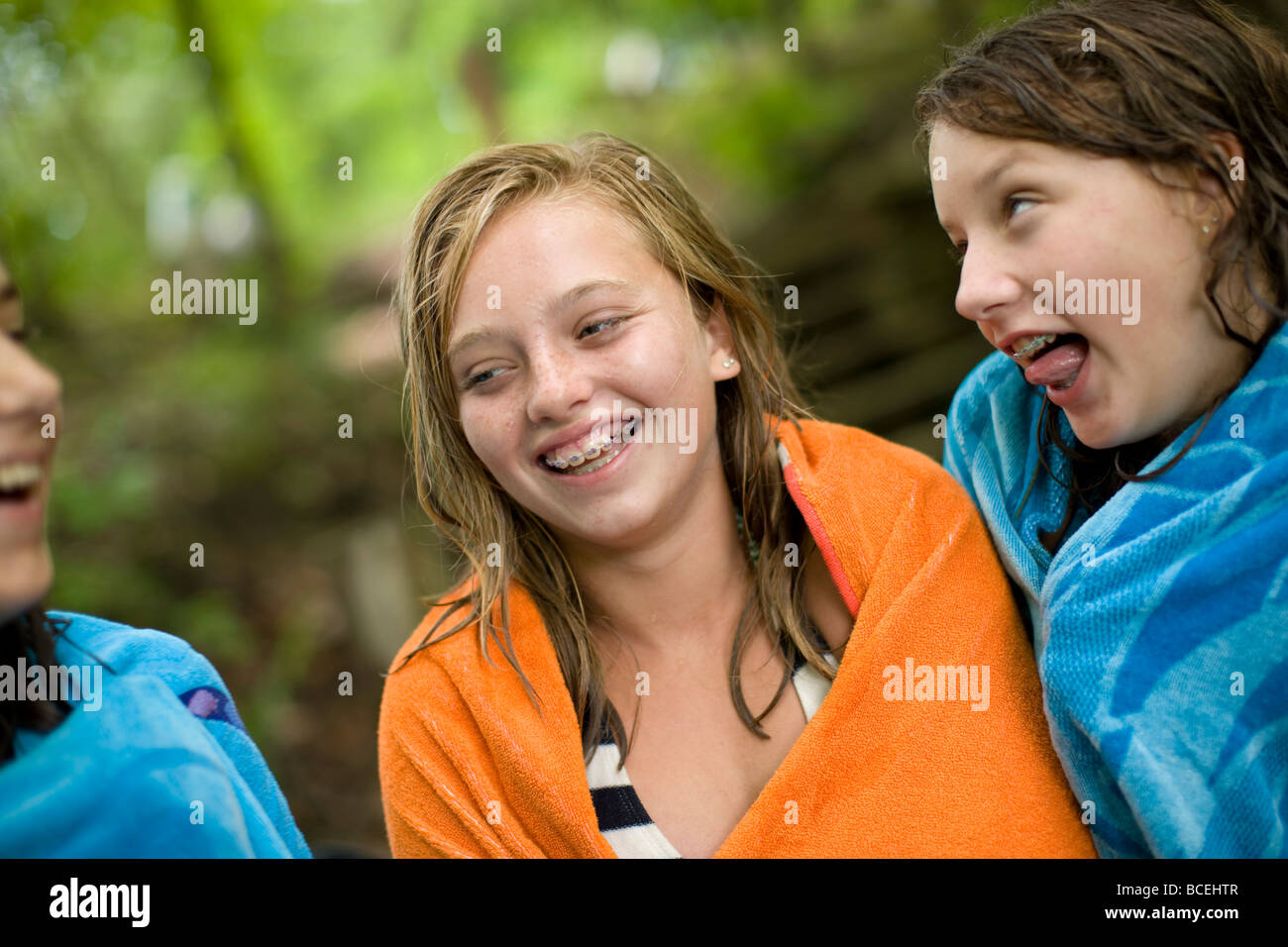 Teenage girls are laughing and having fun while wrapped up in beach ...