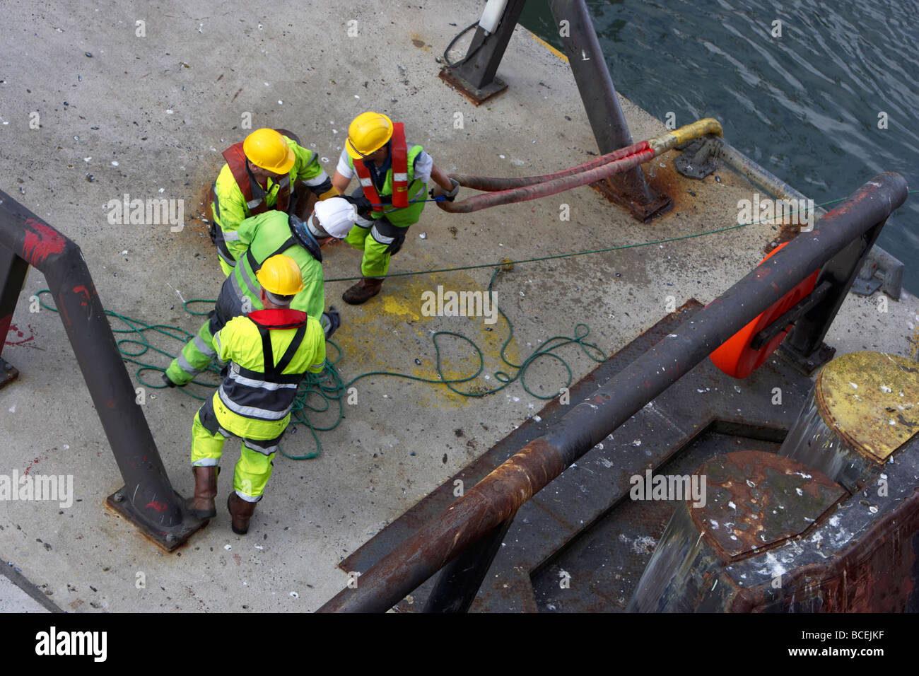 shore crew pull ship rope onto quay while mooring in the port of ...