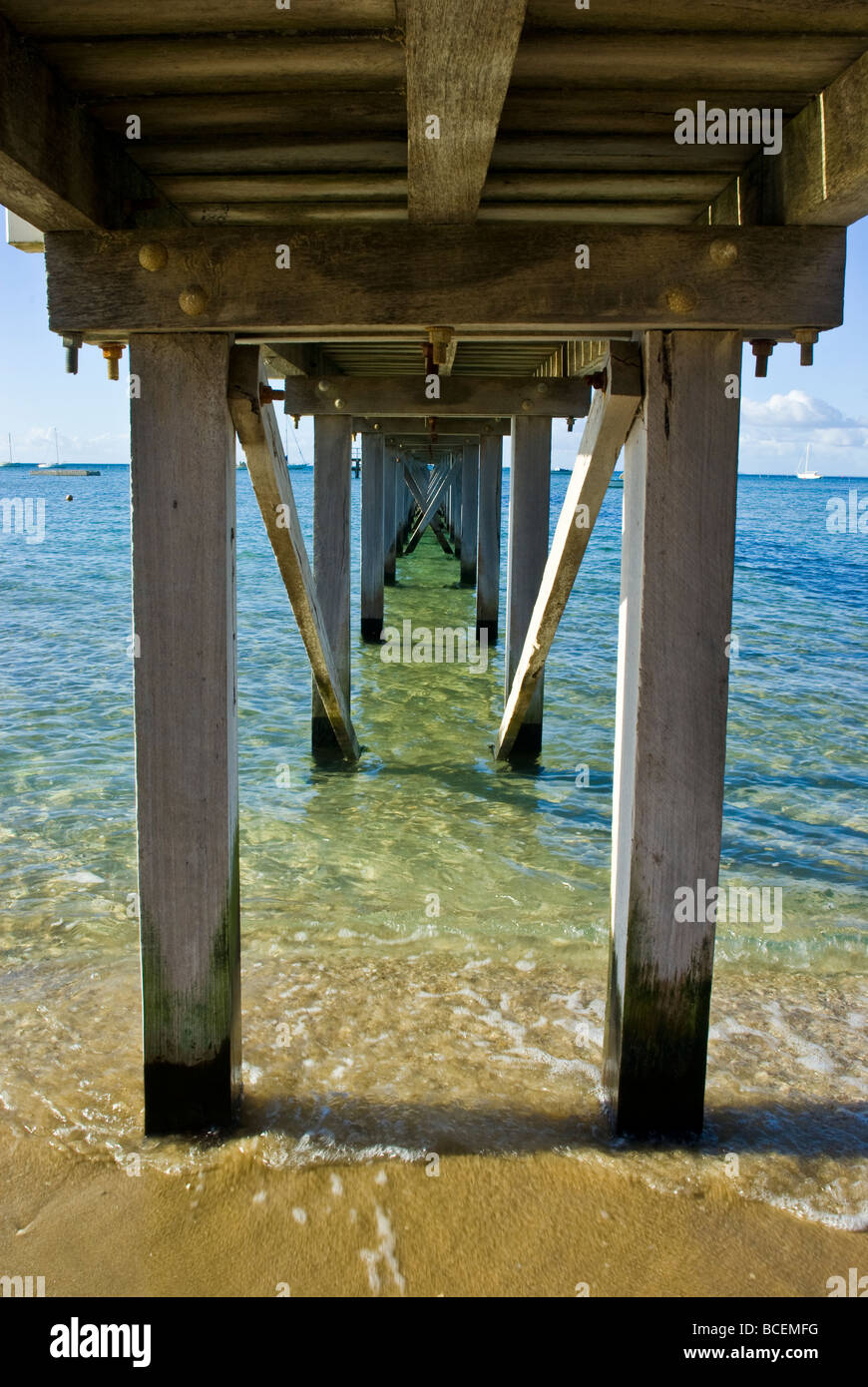 A small wooden jetty reaches into a bay on a clear winters day Stock ...