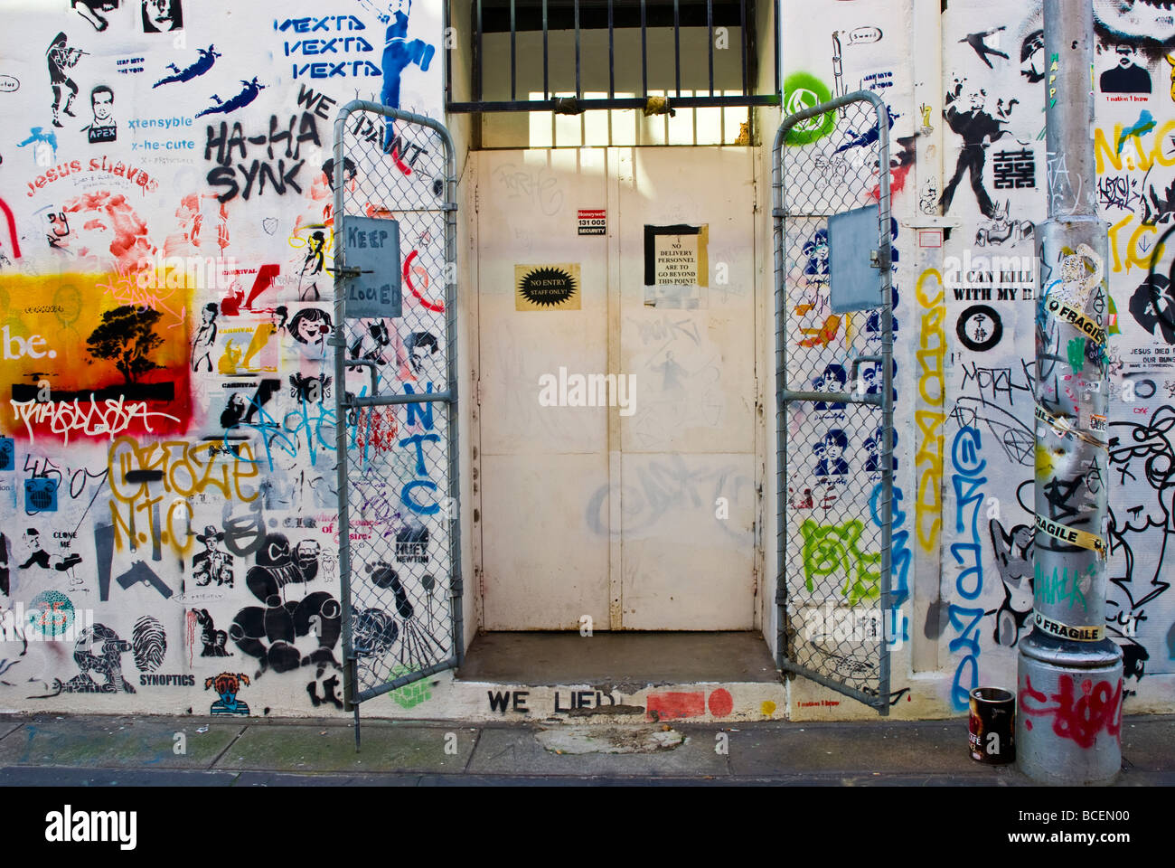 Graffiti artists leave their mark on a building wall in a city lane ...