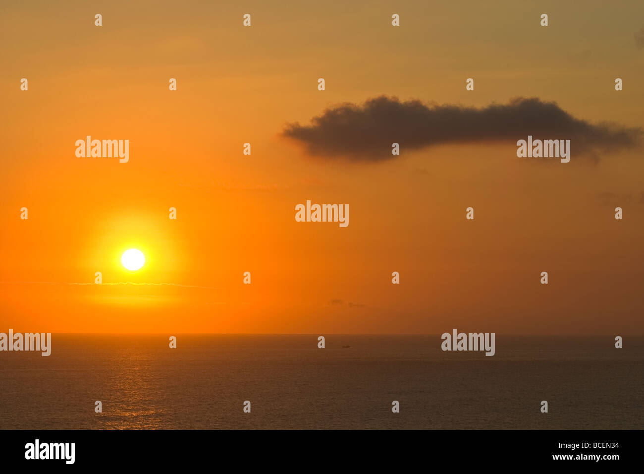 A flaming tropical island sunset over the seas of the Bali Strait Stock ...