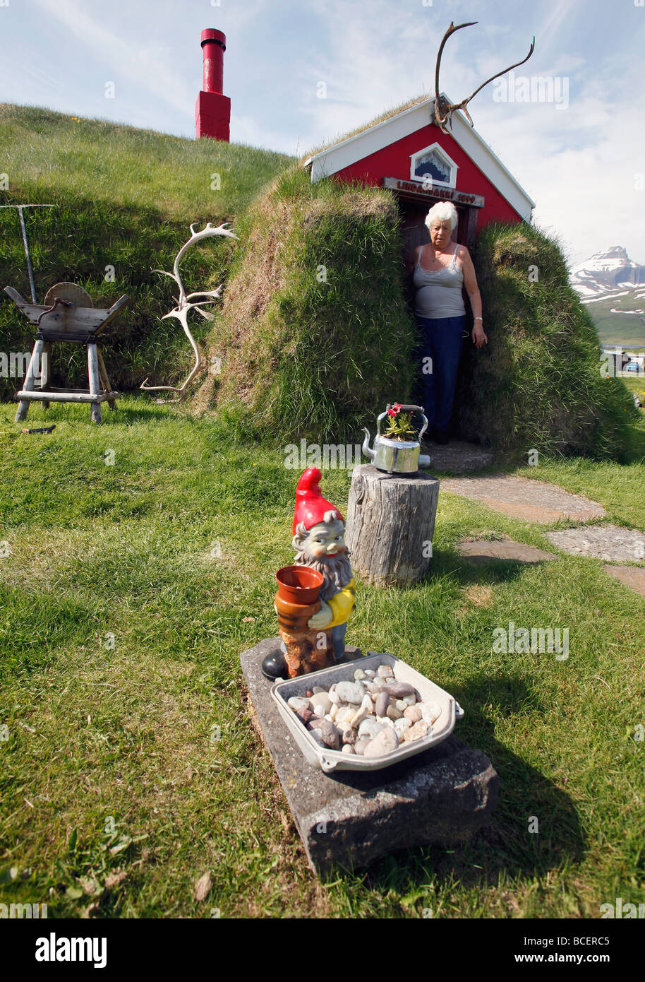 A woman stands in the doorway of her traditional turf house in the ...