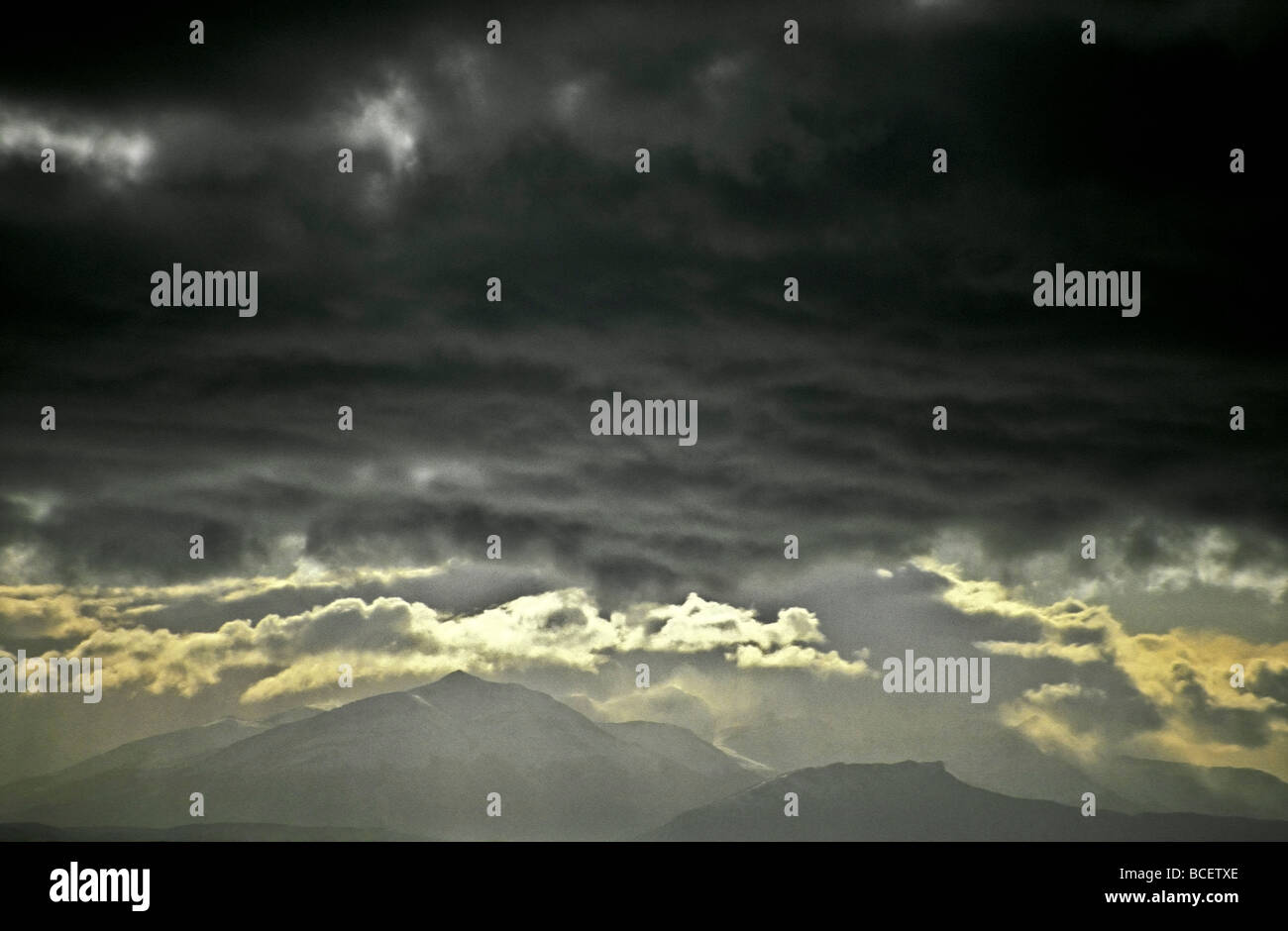 Storm clouds roil over the rugged peaks of the Andes Mountain range ...