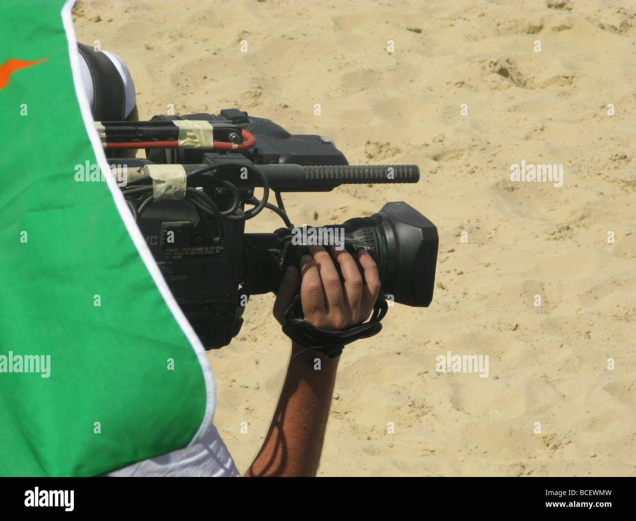 man with tv camera filming at beach event Stock Photo - Alamy