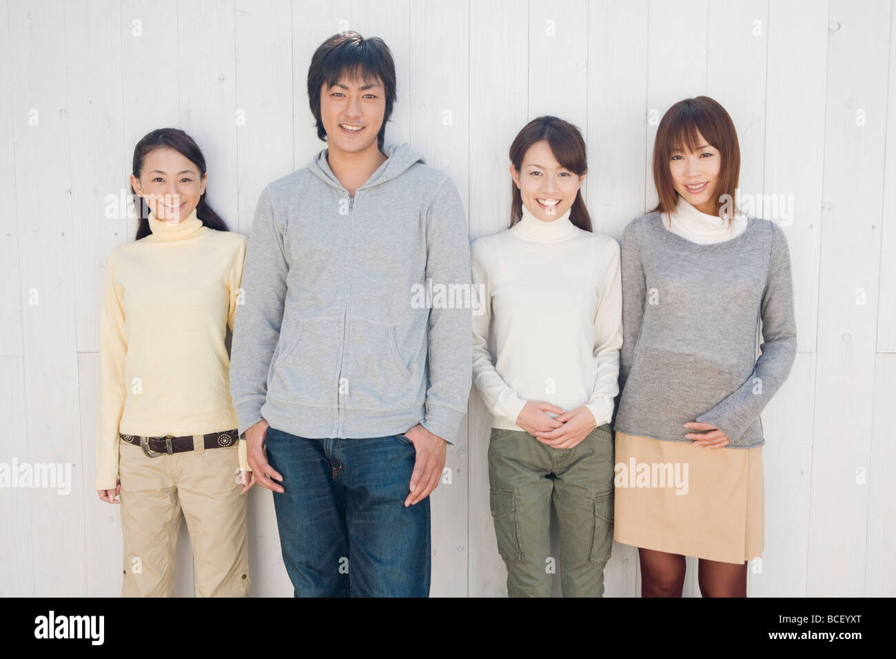 Young people standing in front of wall Stock Photo - Alamy