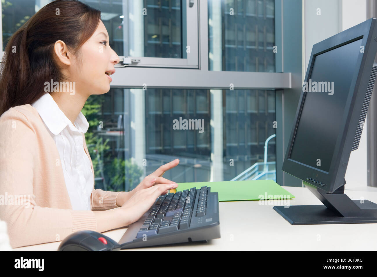 Young woman looking computer display Stock Photo - Alamy