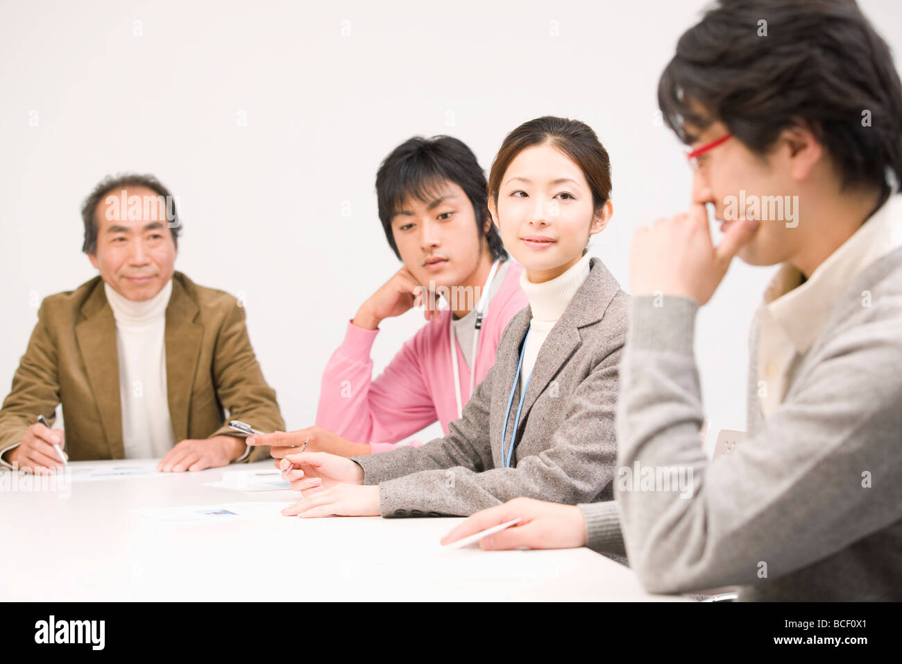 Four people discussing in meeting room Stock Photo - Alamy