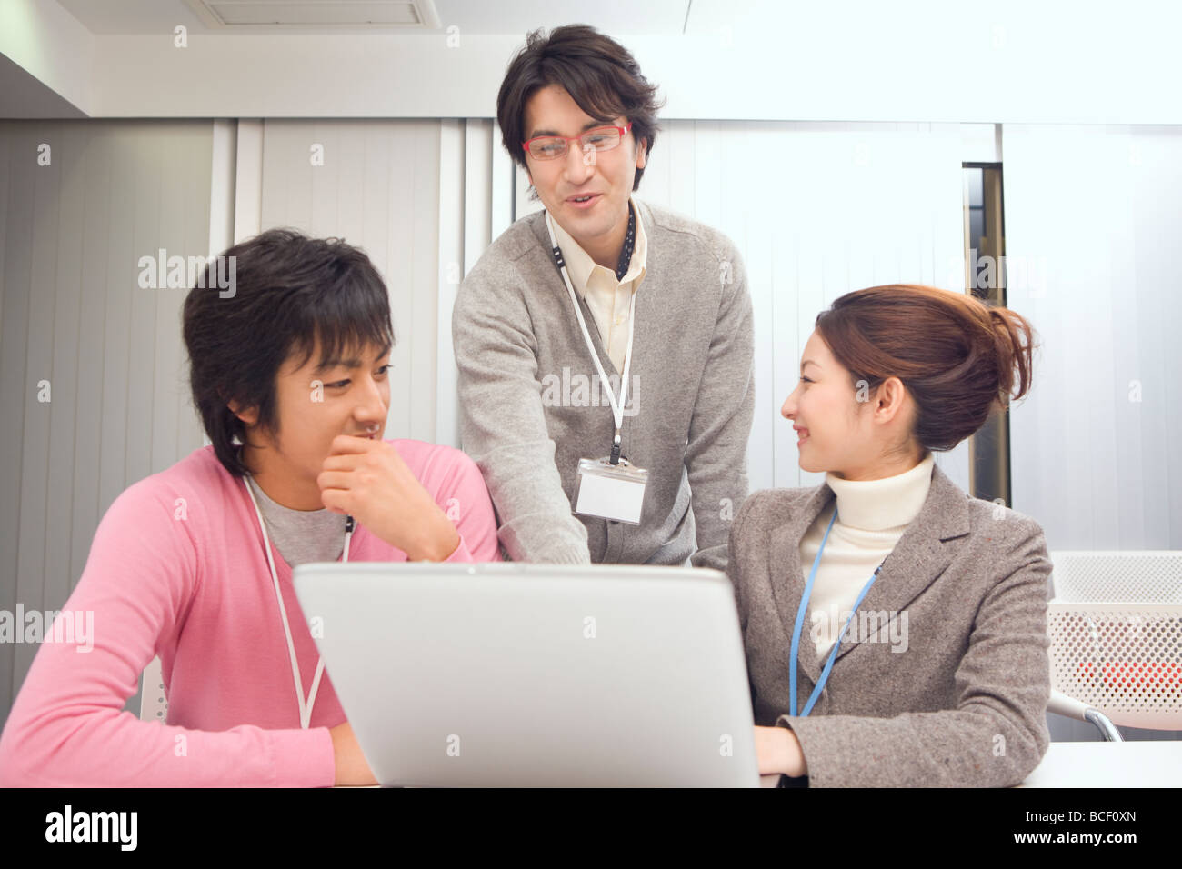 Three people discussing in office Stock Photo - Alamy