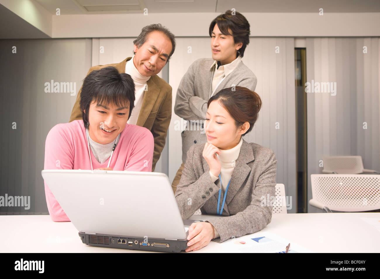Four people discussing in office Stock Photo - Alamy