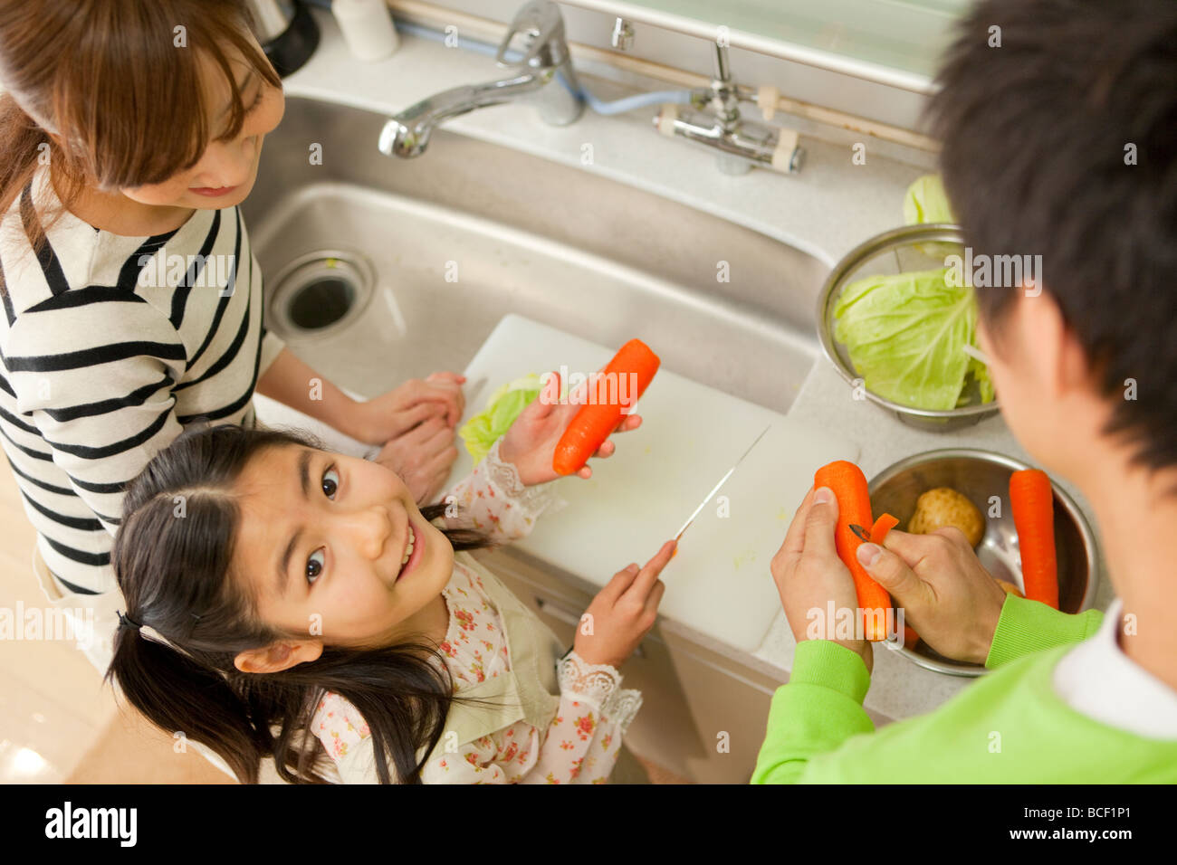 Parents and daughter cooking Stock Photo - Alamy