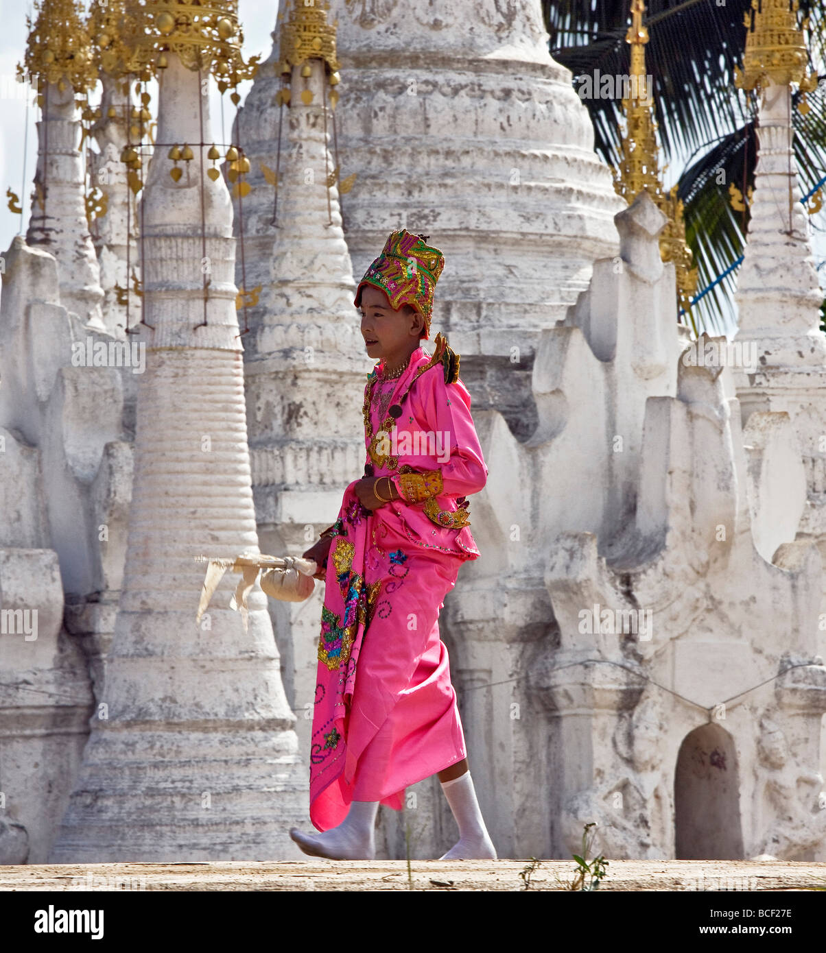 Myanmar. Burma. Lake Inle. A young novitiate passes an ornate Buddhist ...