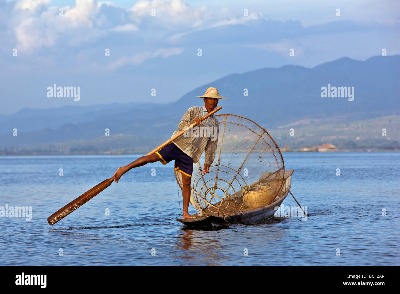 Myanmar, Burma, Lake Inle. An Intha fisherman with a traditional fish ...