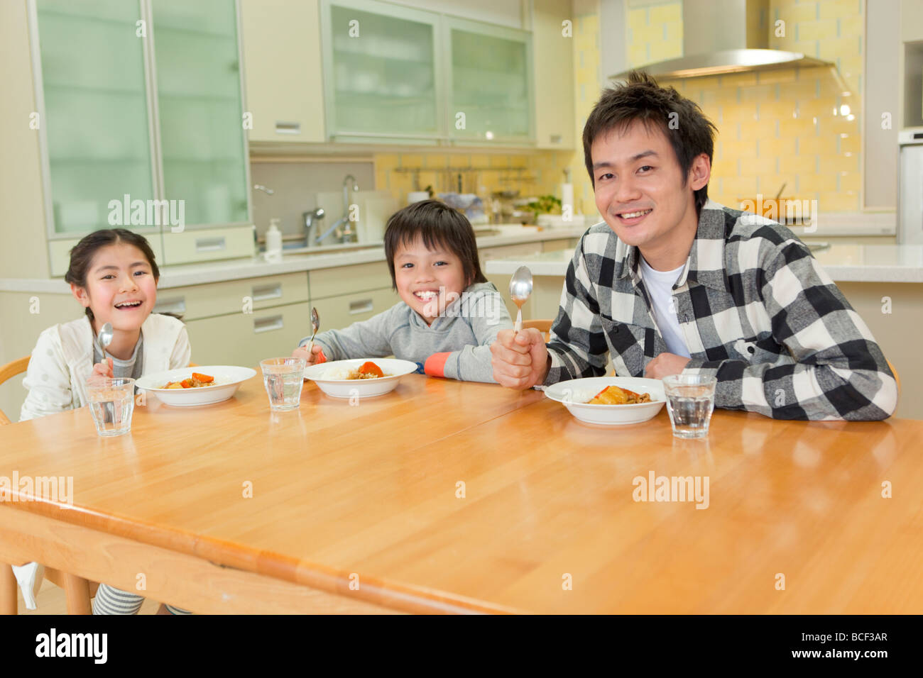 Father and children eating curry and rice Stock Photo - Alamy