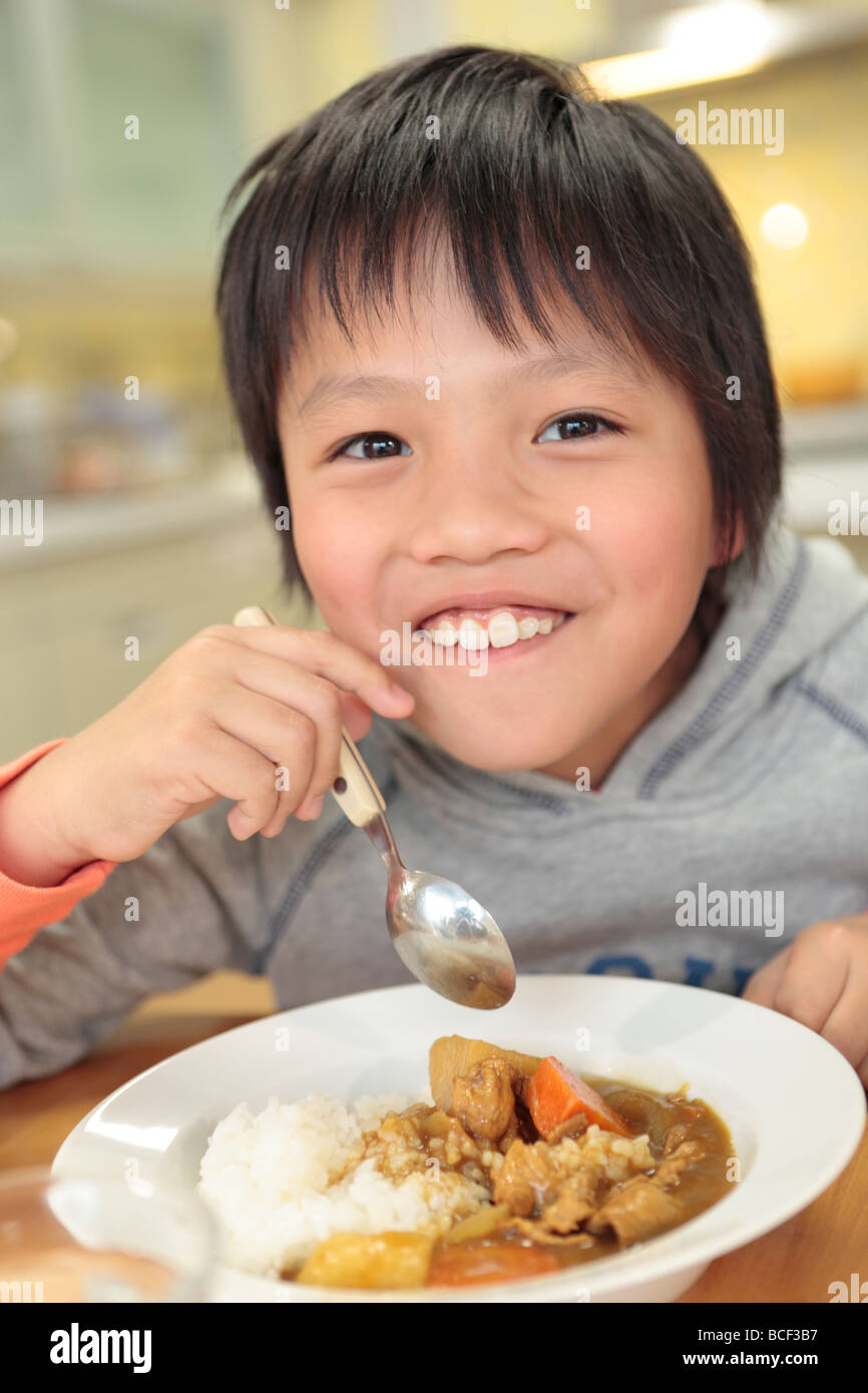 Boy eating curry and rice Stock Photo - Alamy