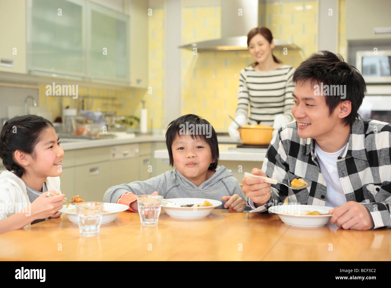 Father and children eating curry and rice Stock Photo - Alamy