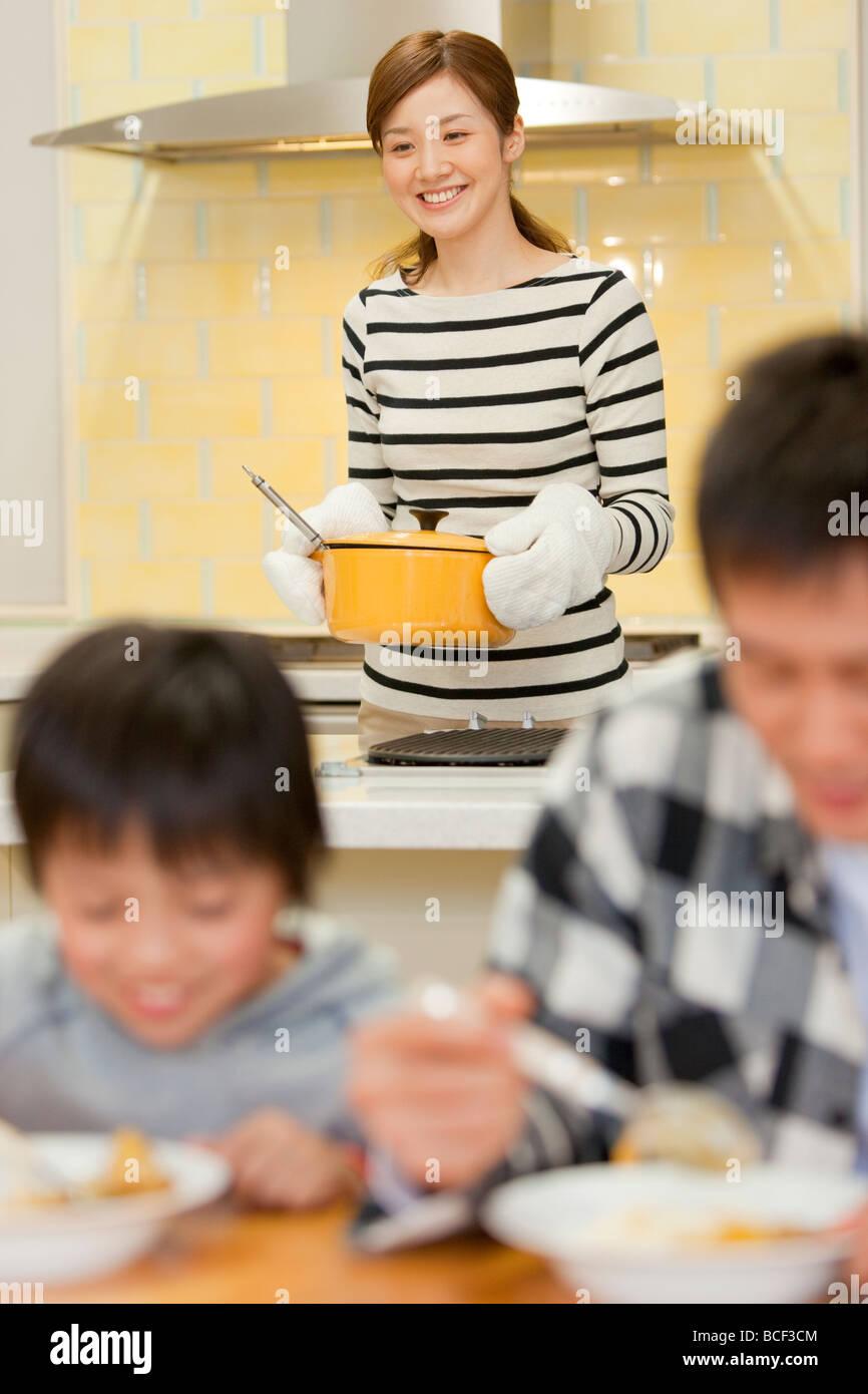 Mother watching family from kitchen Stock Photo - Alamy
