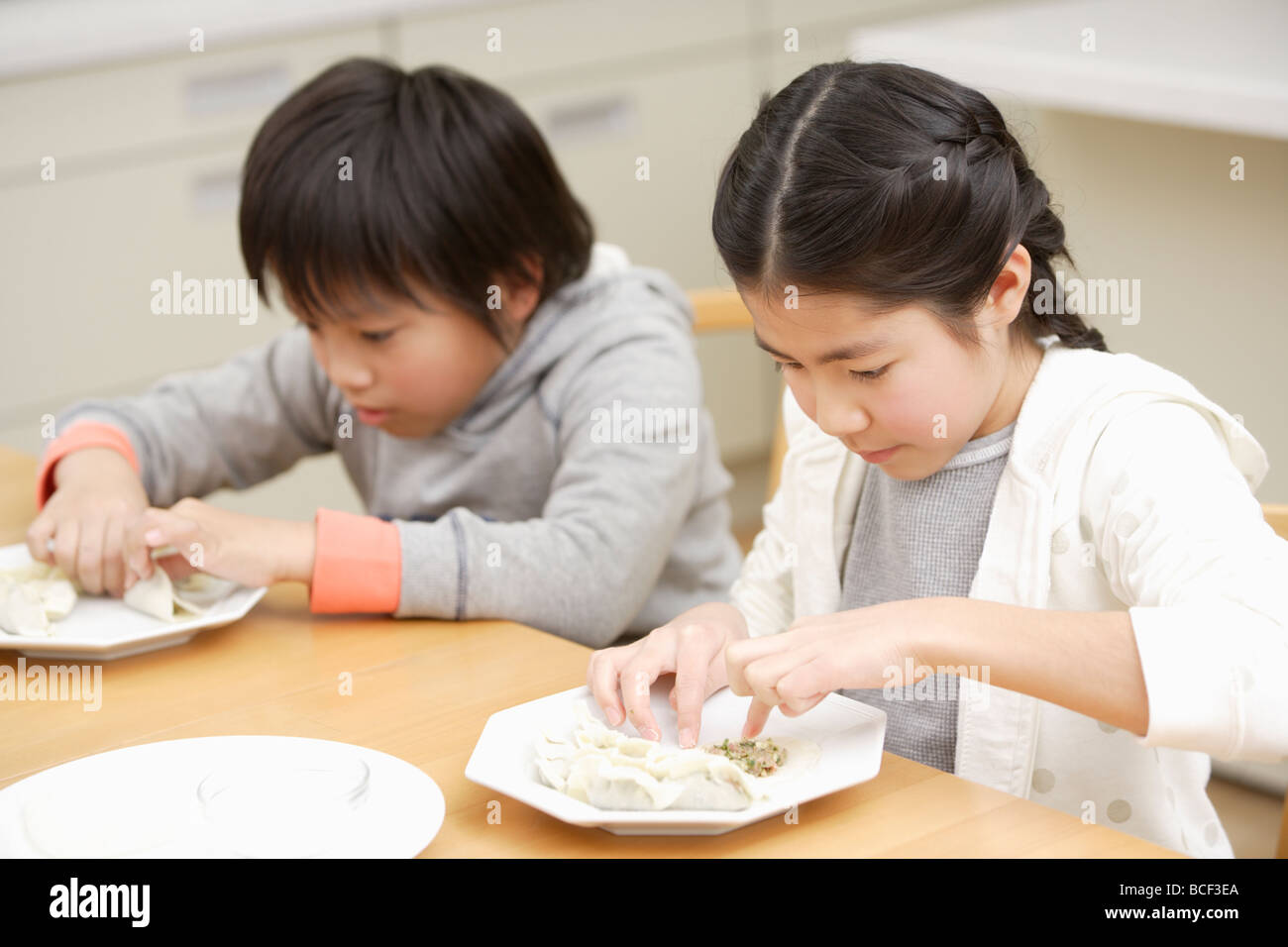 Two children making pot-sticker Stock Photo - Alamy